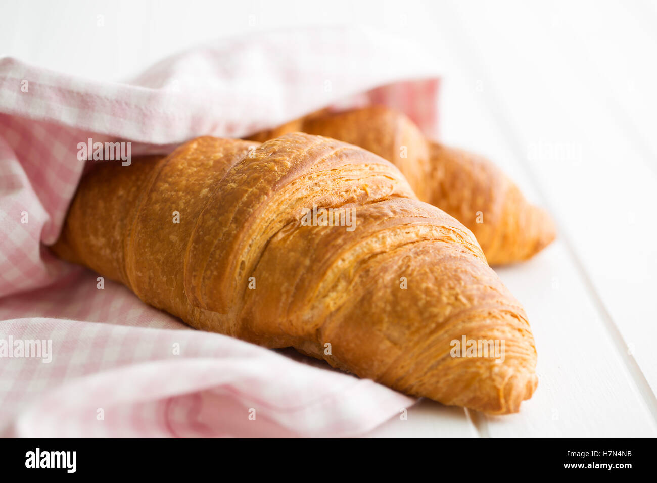 Tasty buttery croissant on white table Stock Photo - Alamy