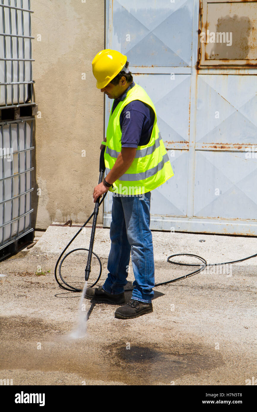 worker cleaning the floor with a pressure washer Stock Photo - Alamy