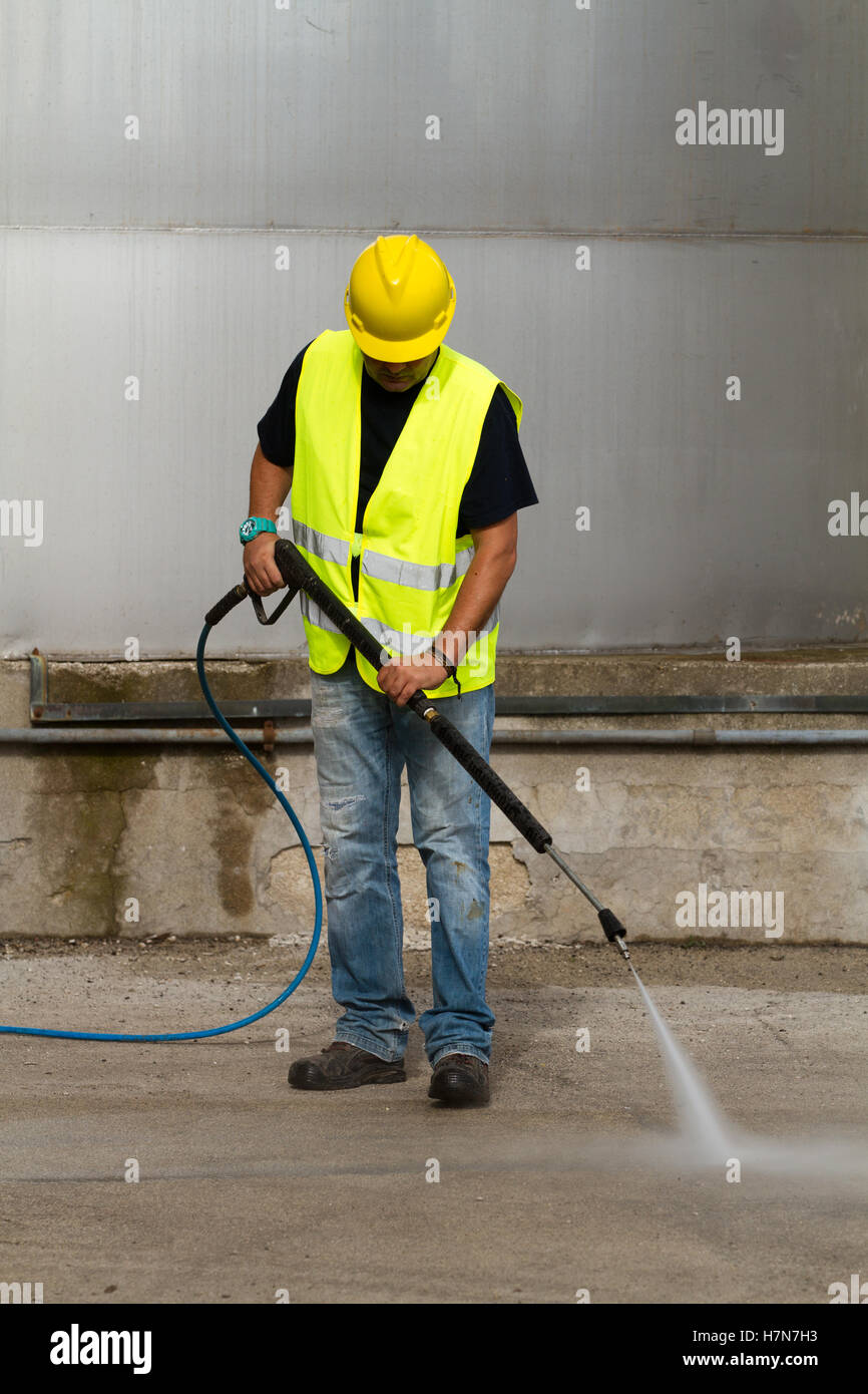 worker cleaning the floor with a pressure washer Stock Photo - Alamy
