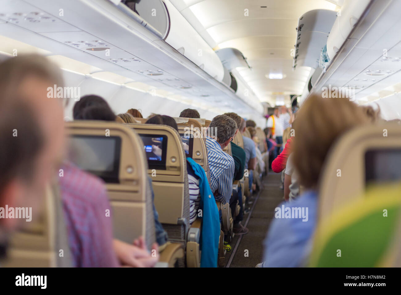 Interior of modern commercial airplane with passengers on their seats ...