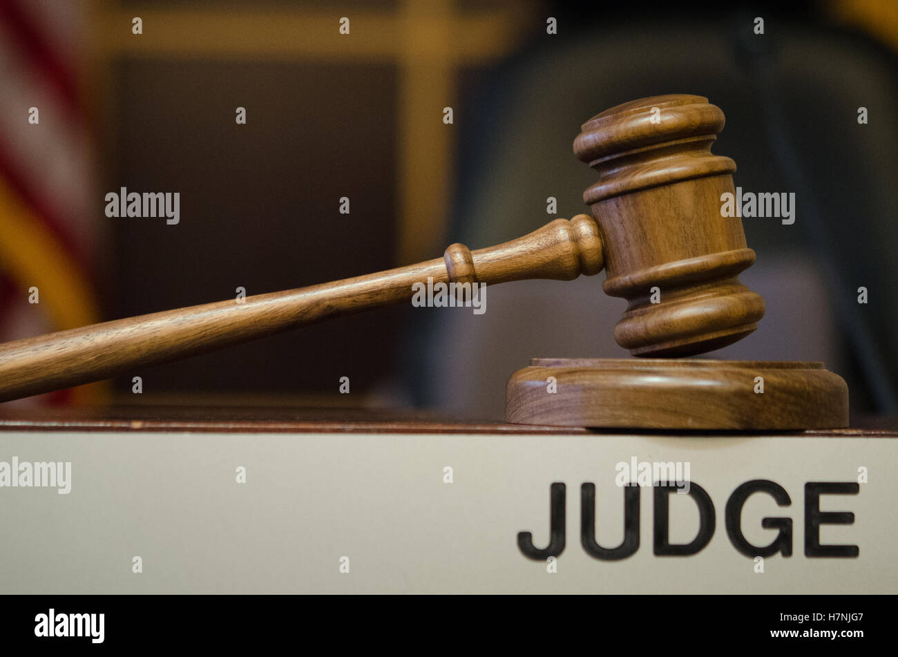 Gavel up at Judge's bench with sign, chair and flag Stock Photo - Alamy