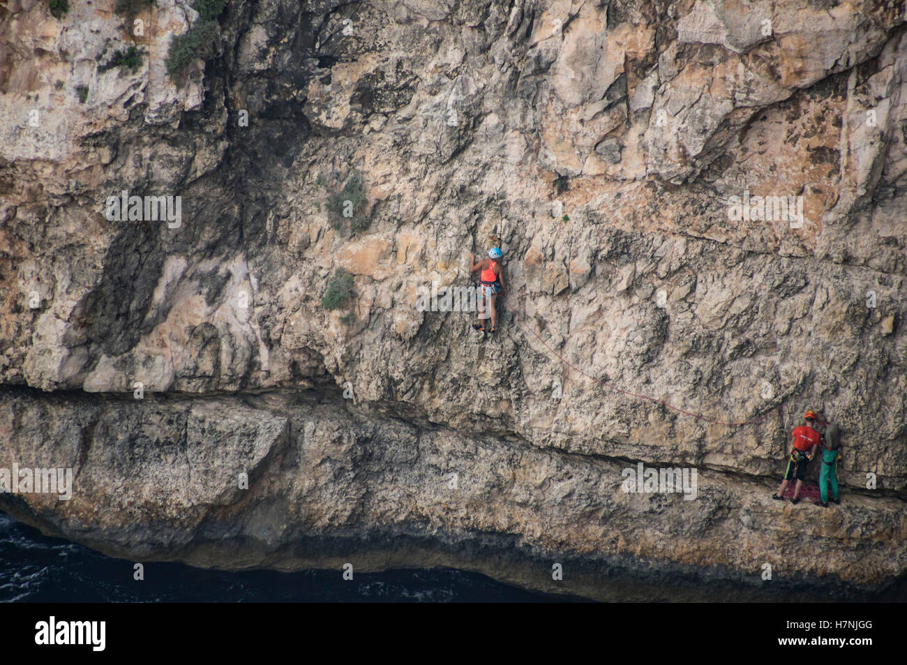 Blue lagoon cliff wall with climbers, Malta Stock Photo - Alamy