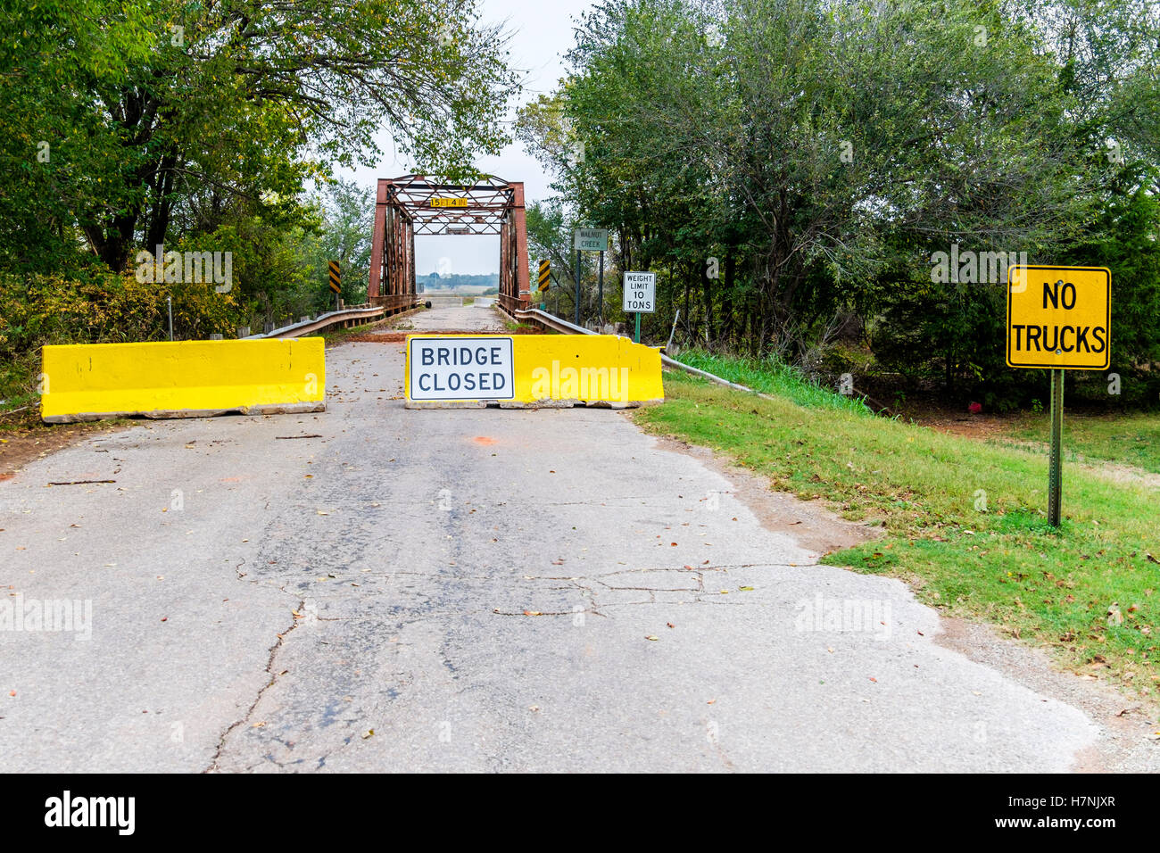 Barriers and a sign warning Bridge Closed at each end of an old truss ...