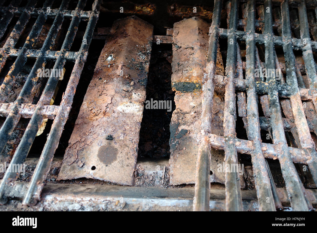 A propane gas grill with lid open showing rust and a deteriorating ...