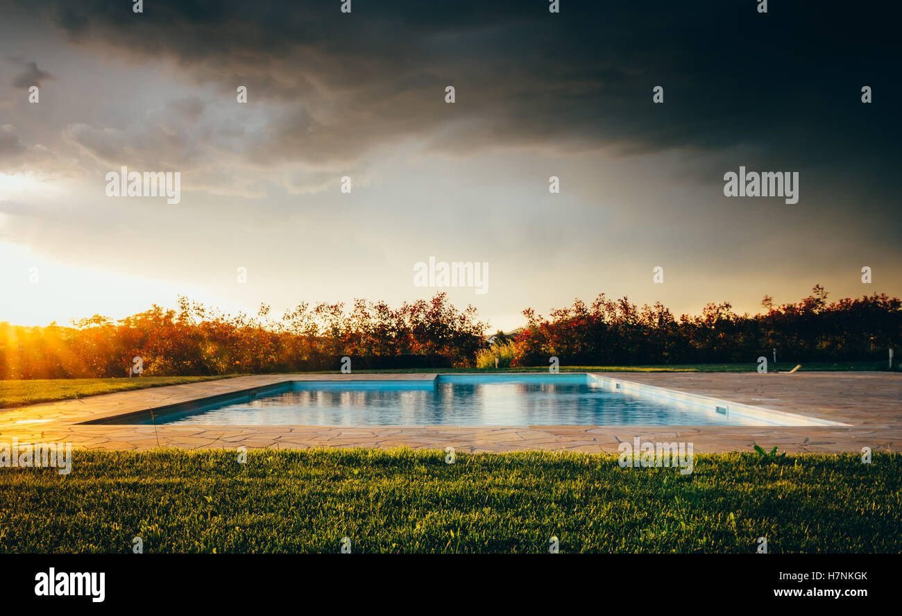 Pool relaxing sunset with storm coming Stock Photo - Alamy