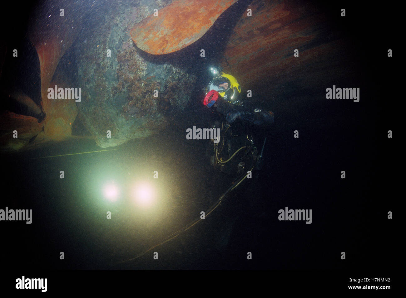 Diver examining boulder embedded in the hull of the sunken Exxon Valdez ...
