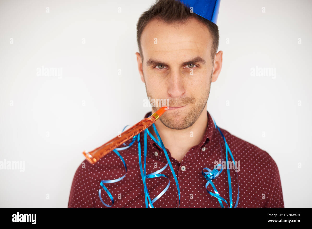 Man posing with party horn blower Stock Photo - Alamy