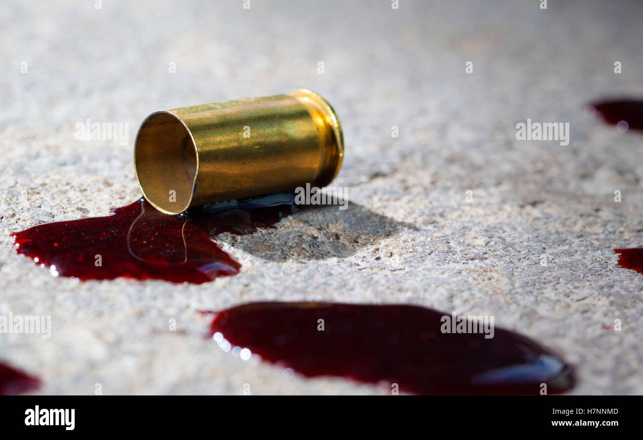 Blood around a single empty handgun casing on concrete Stock Photo - Alamy