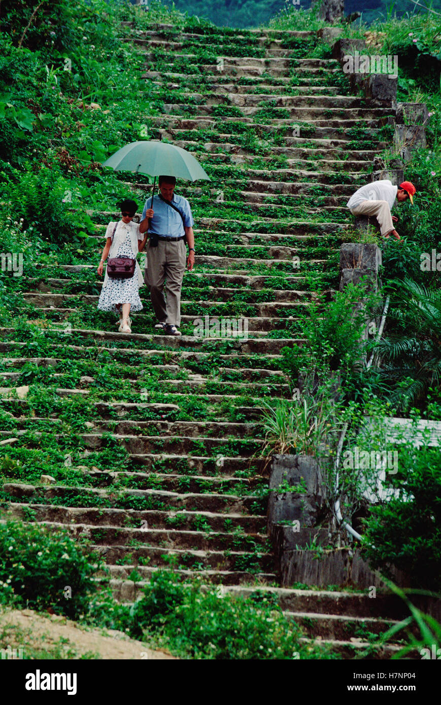 Tourists descending an old French staircase, Tam Dao National Park ...
