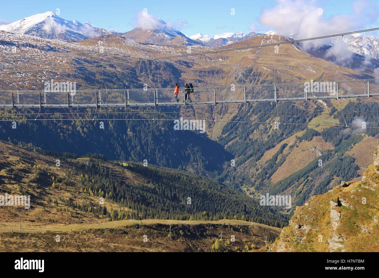 People cross a suspension bridge on the Stubnerkogel, Gastein mountains ...