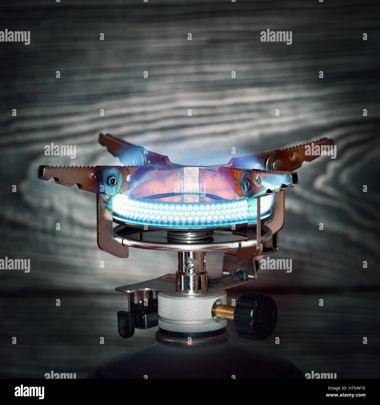 The burning portable gas burner on wooden background Stock Photo - Alamy