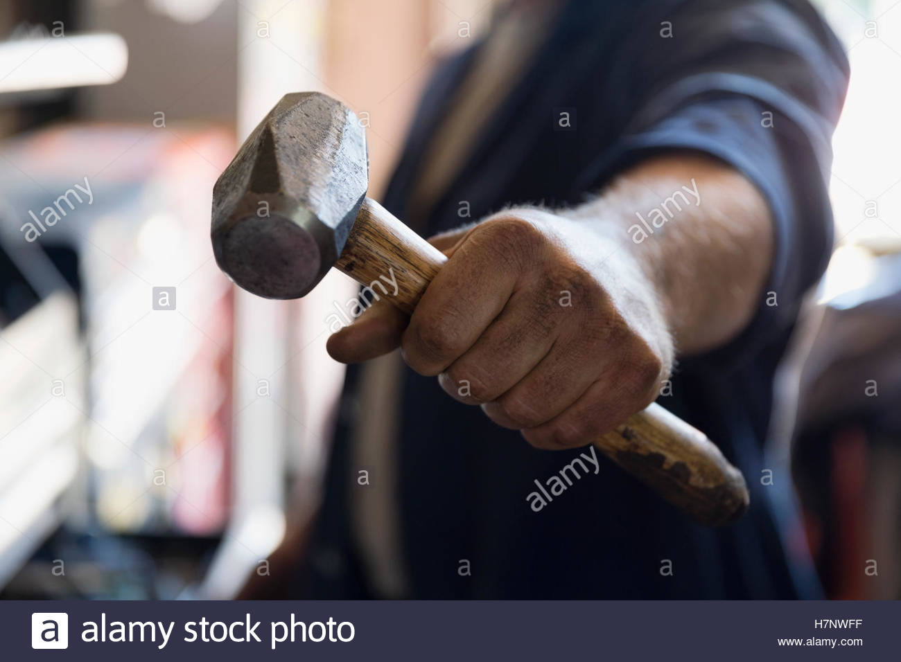 Close up male mechanic holding metal hammer Stock Photo - Alamy