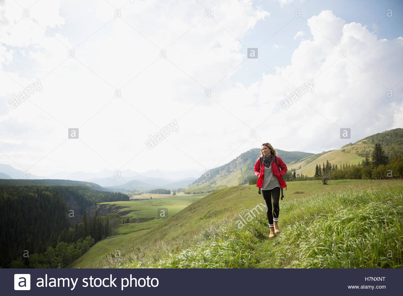 Woman with backpack hiking in remote sunny rural field Stock Photo - Alamy