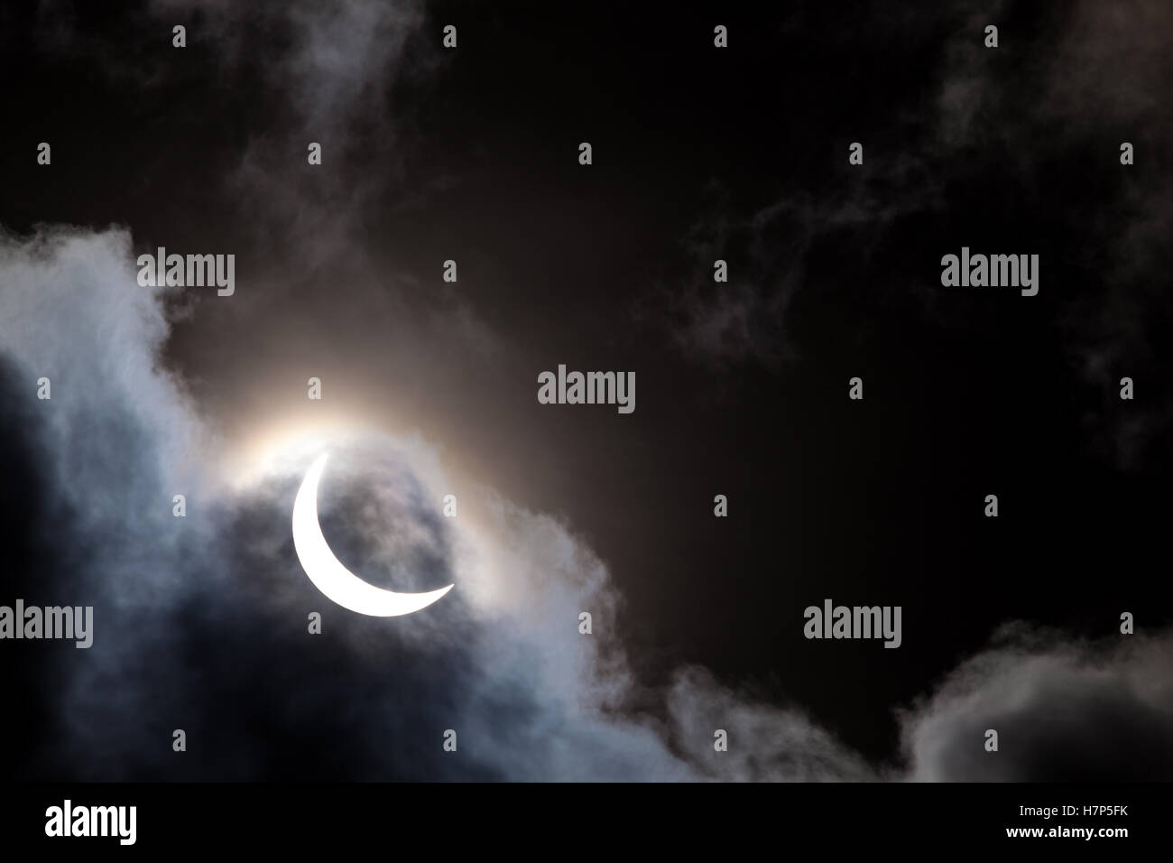 Partial solar eclipse through clouds Stock Photo - Alamy
