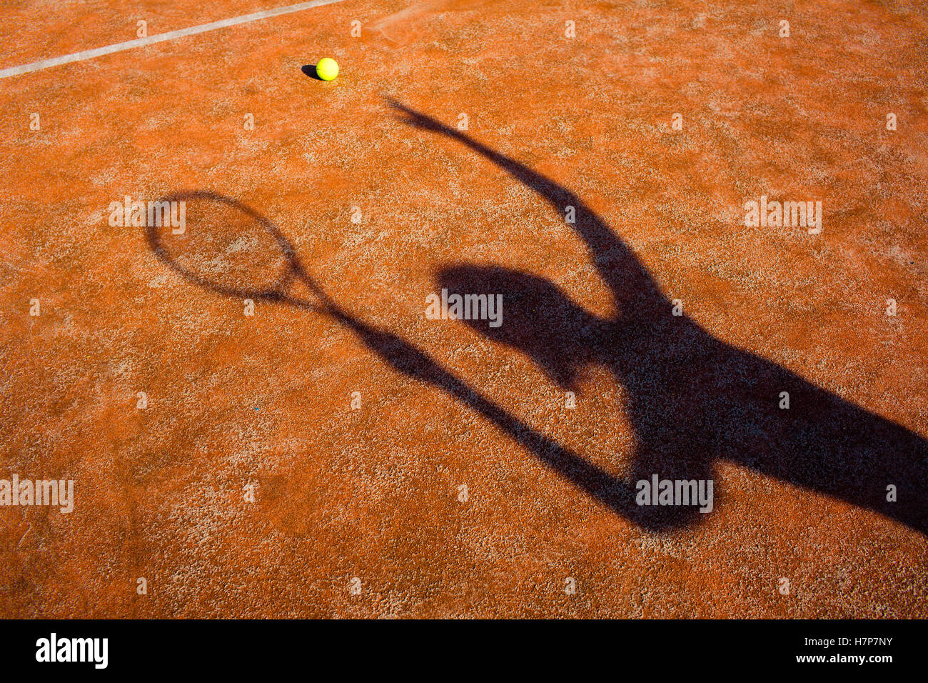 shadow of a tennis player in action on a tennis court (conceptual image ...