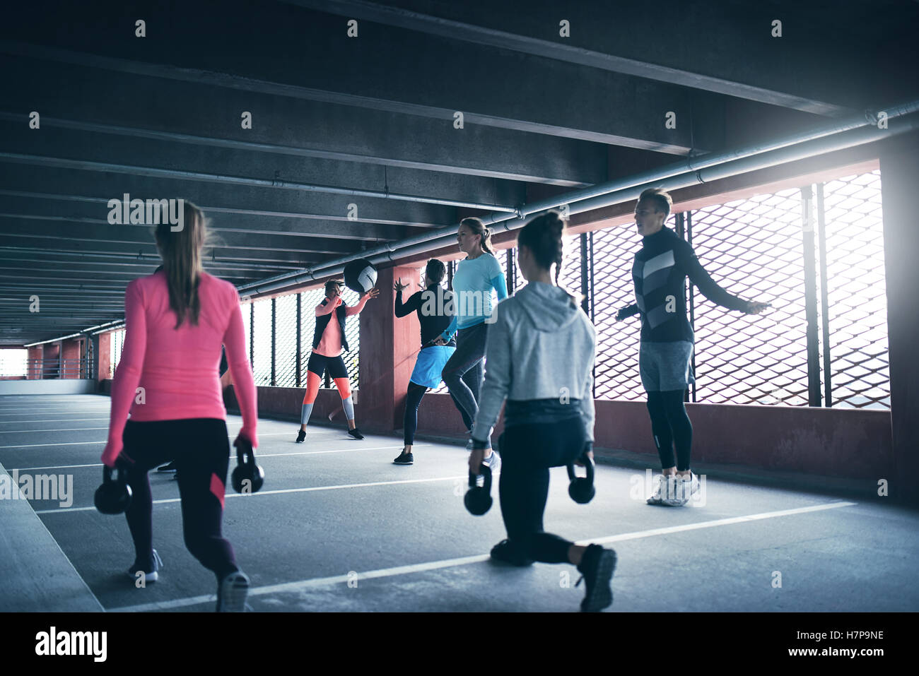 Group of people exercising using weights and skipping ropes, wearing ...
