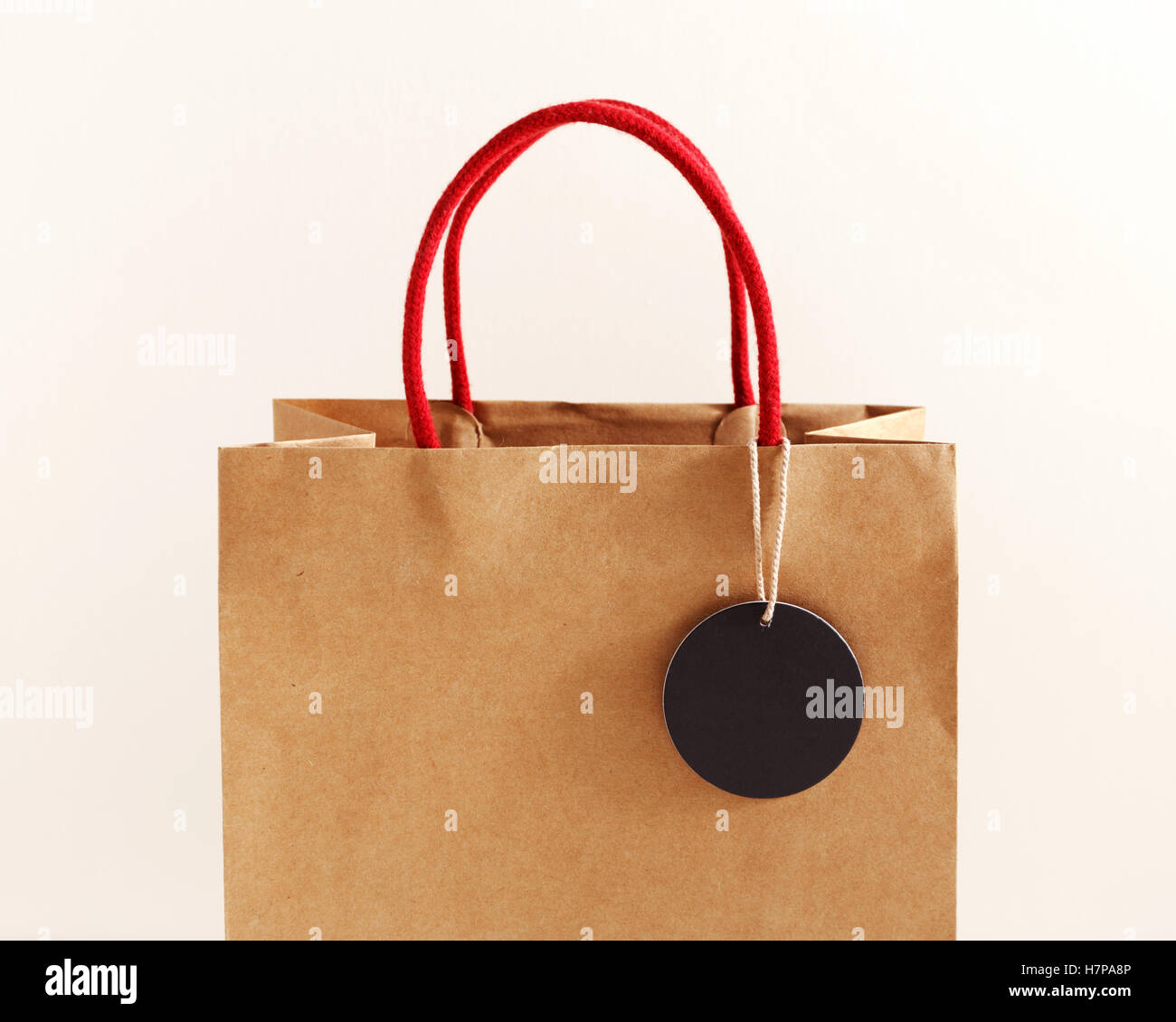 Brown paper shopping bag with black tag and red rope handle Stock Photo ...