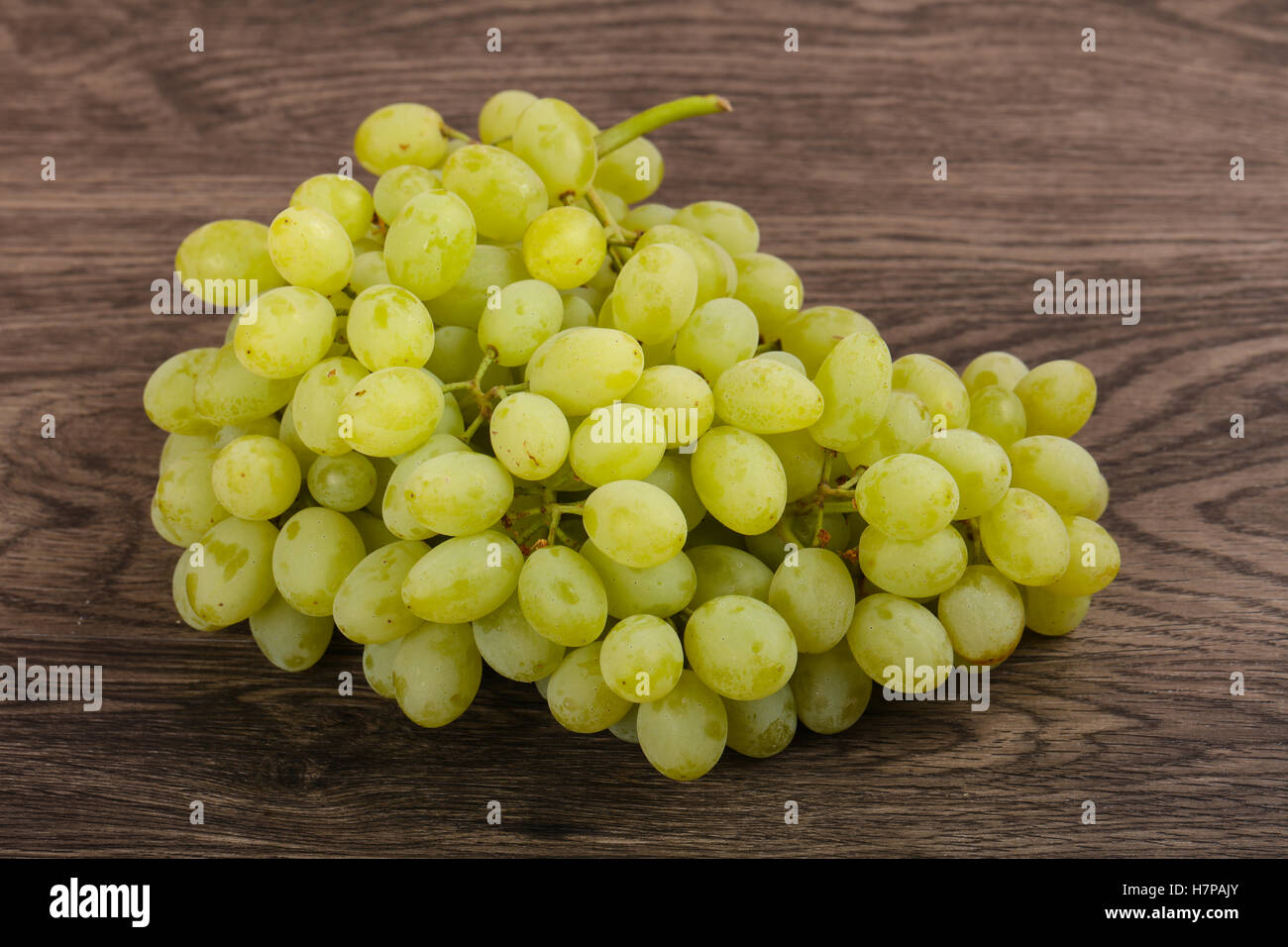 Sweet yellow grape heap on the wood background Stock Photo - Alamy