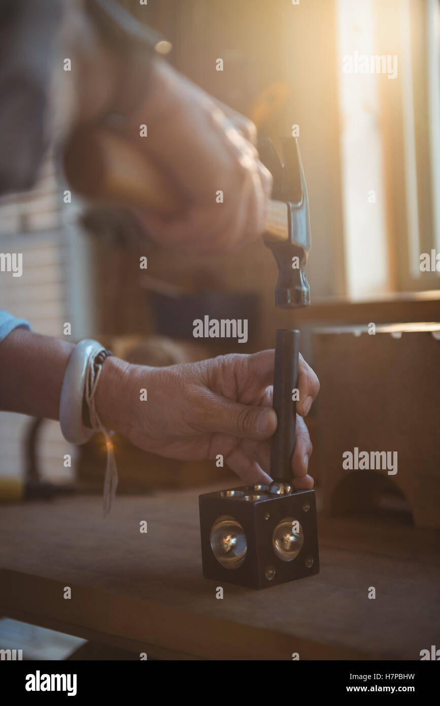 Hands of craftswoman using hammer Stock Photo - Alamy