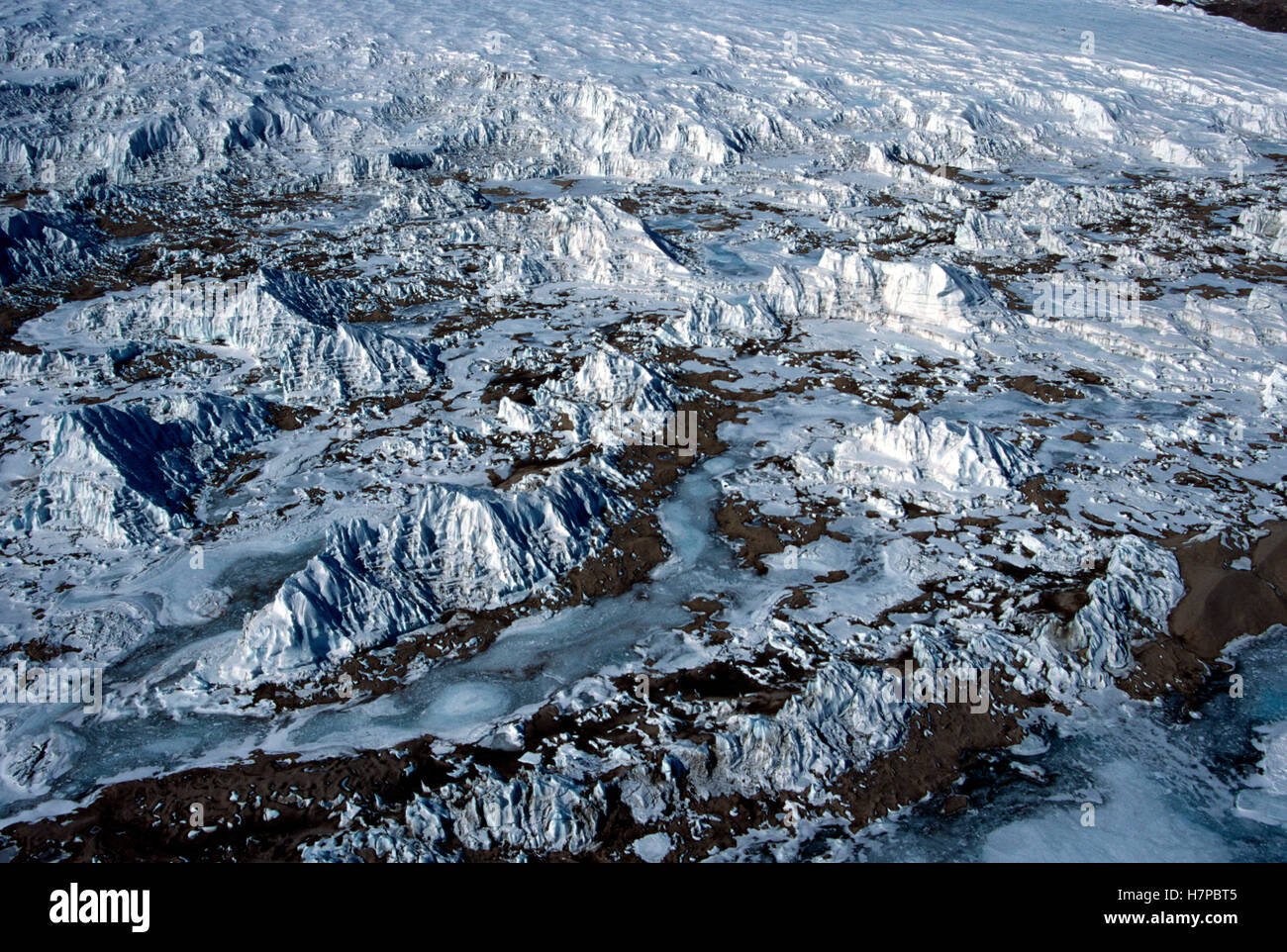 Aerial view of windswept ice formations at the base of a glacier in the ...