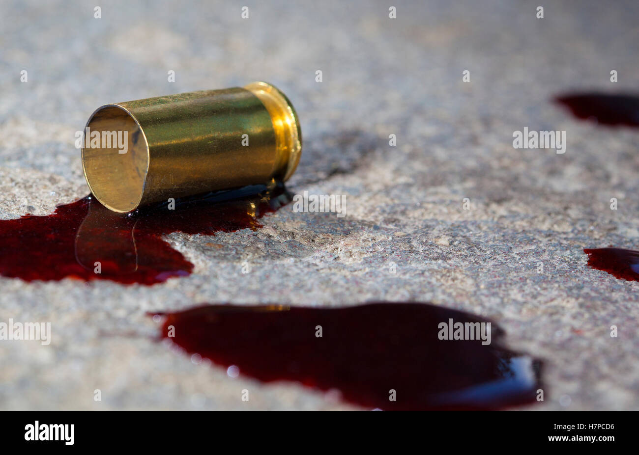 Handgun brass with some blood on the concrete Stock Photo - Alamy