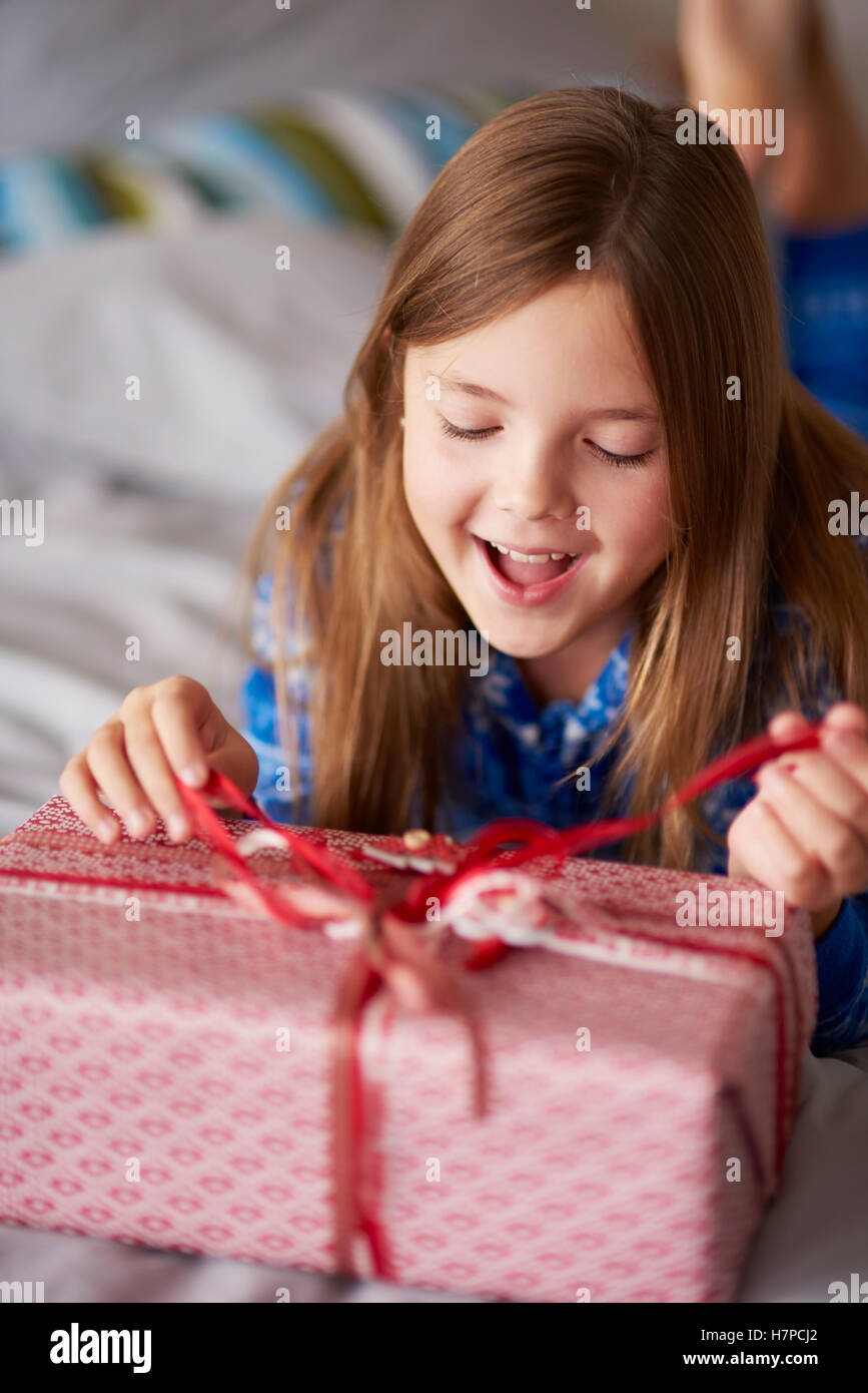 Exciting girl opening Christmas present Stock Photo - Alamy