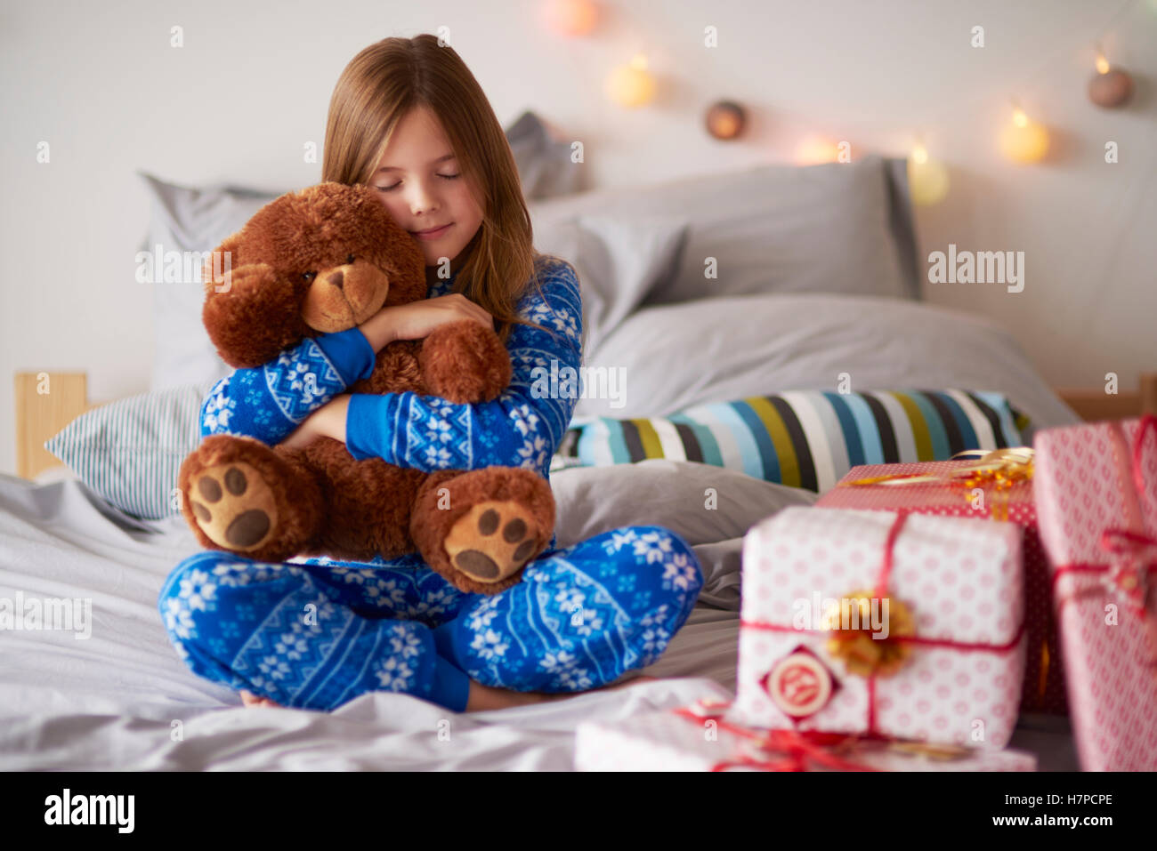 Little girl embracing teddy bear at Christmas Stock Photo - Alamy