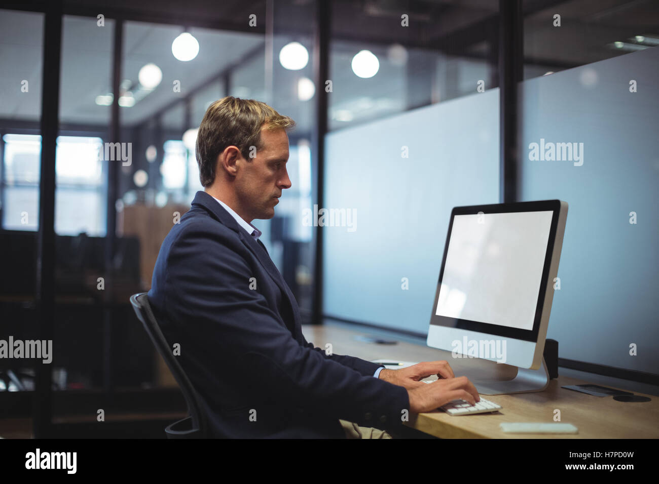 Businessman using desktop pc at desk Stock Photo - Alamy