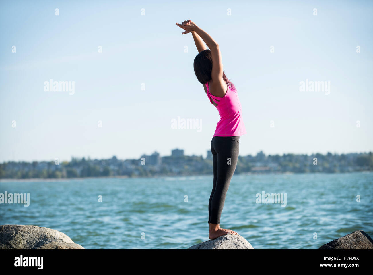 Woman performing yoga on rock Stock Photo - Alamy