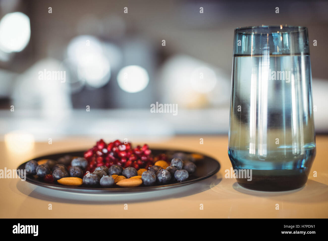 Plate of snacks and water glass on table Stock Photo - Alamy