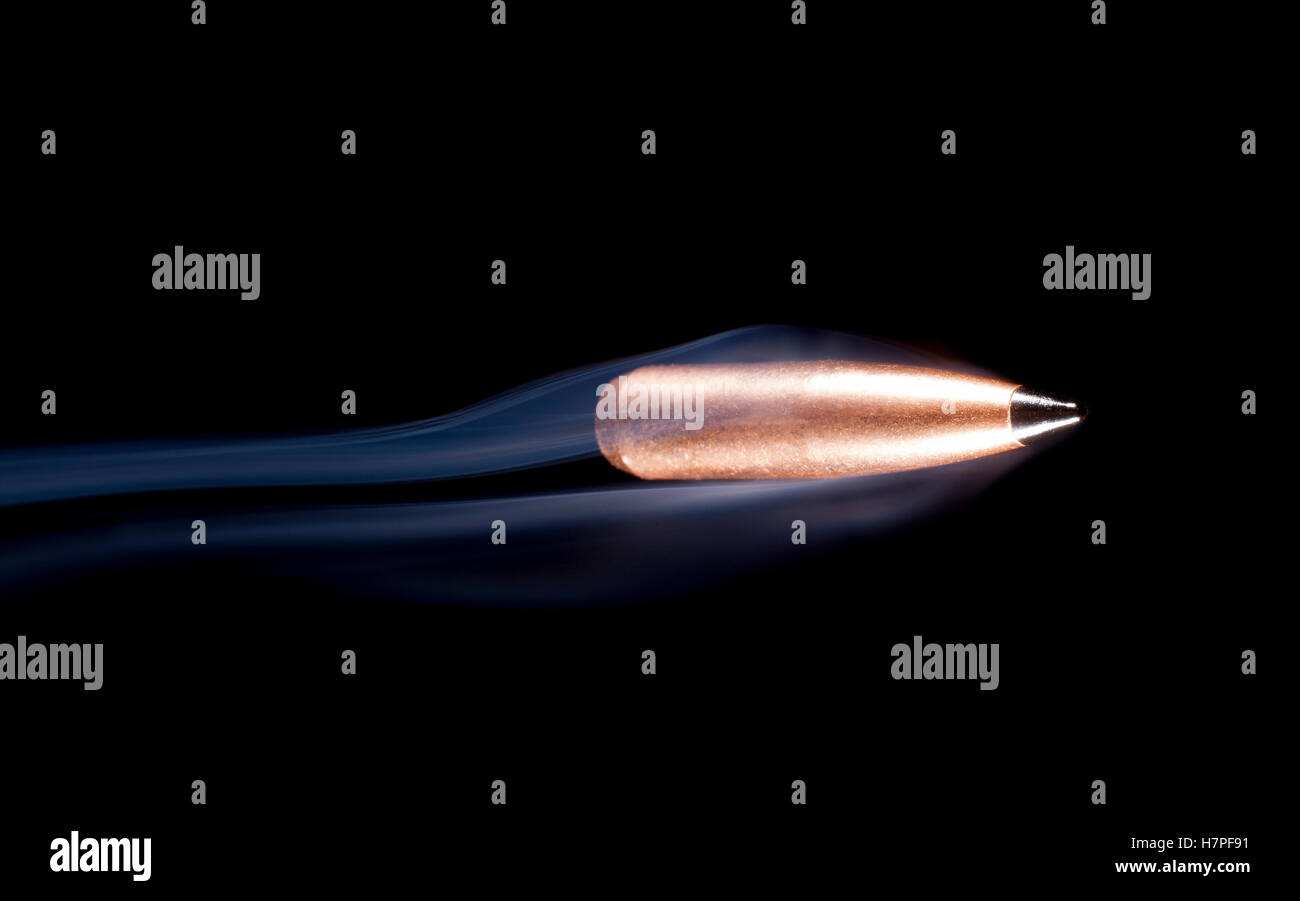 Copper plated bullet with polymer tip on the way to the target Stock ...