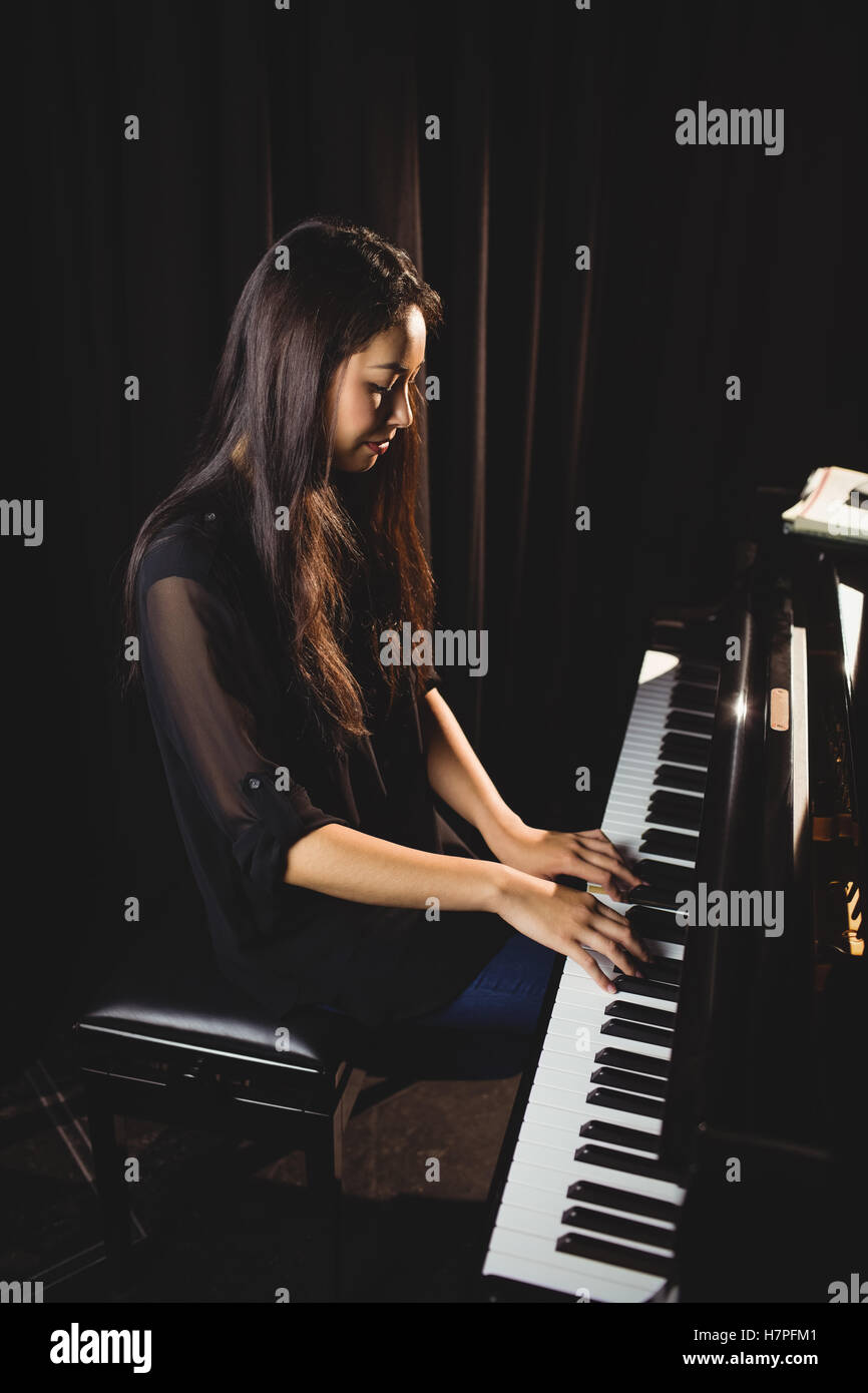 Woman playing a piano in music studio Stock Photo - Alamy