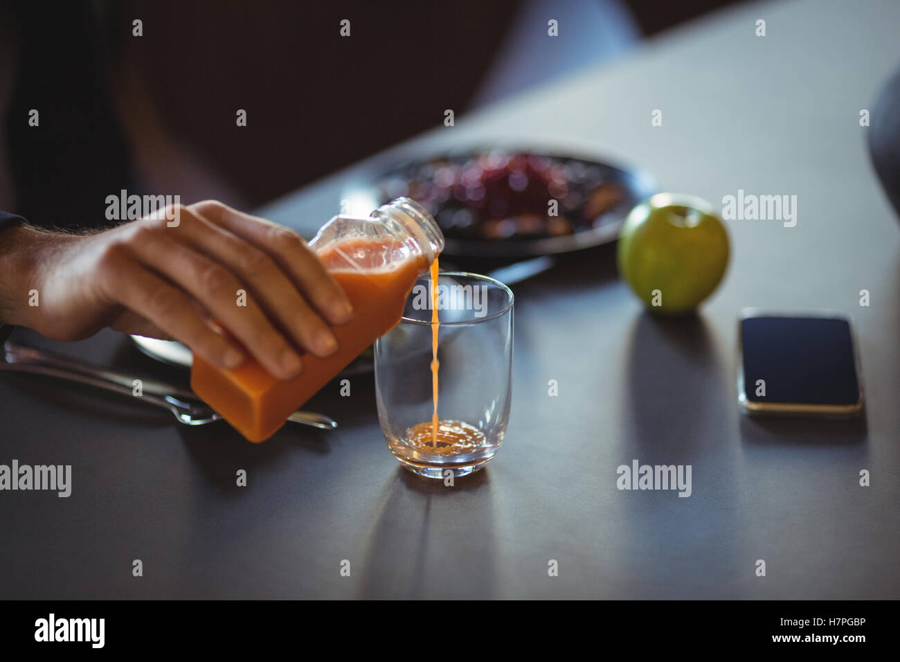 Hand pouring juice in glass Stock Photo - Alamy