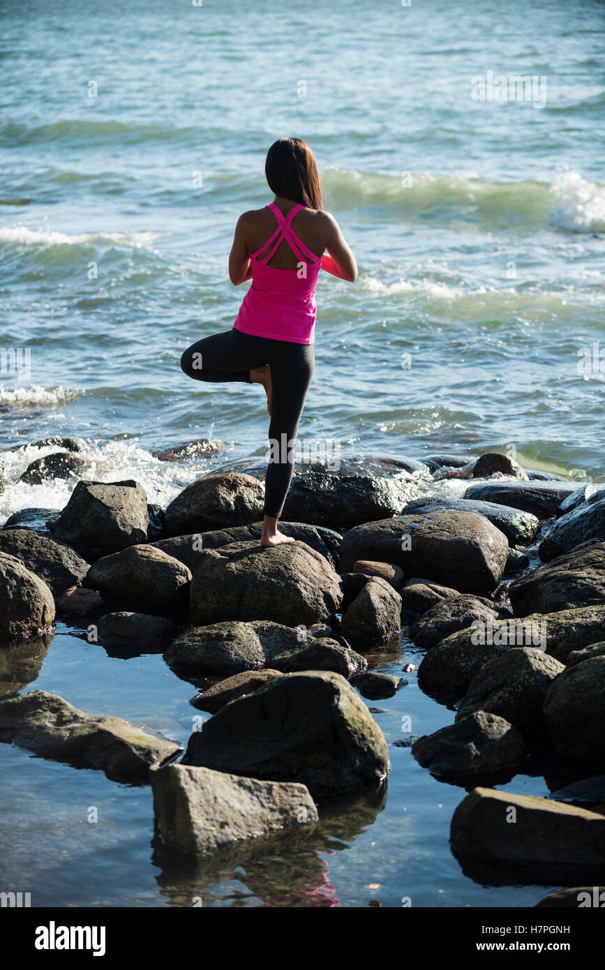 Rear view of woman performing yoga on rock Stock Photo - Alamy Rear view of woman performing yoga on rock Stock Photo - Alamy