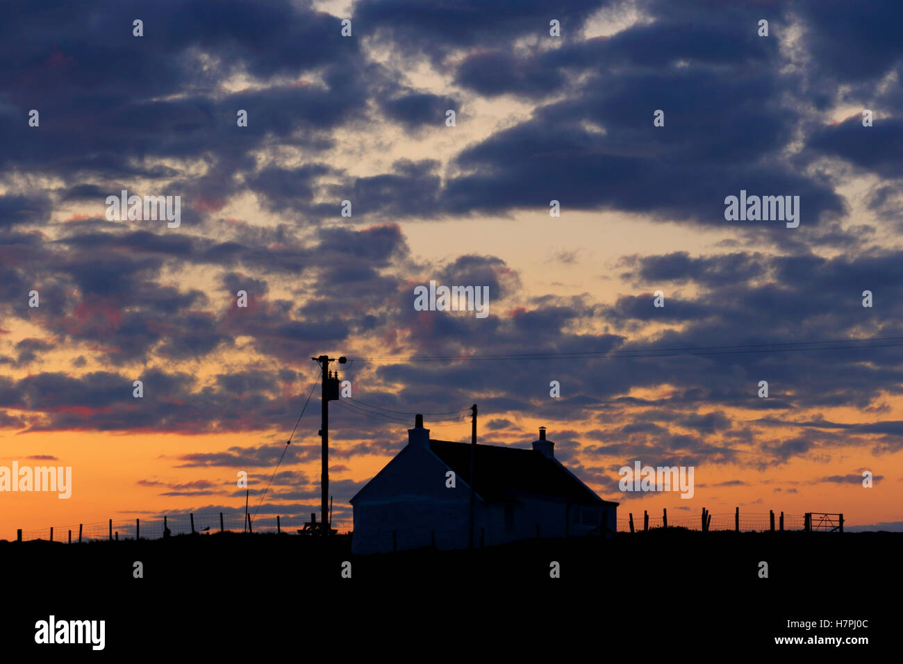 Sunset behind a typical Hebridean single story home Traigh an Iar ...