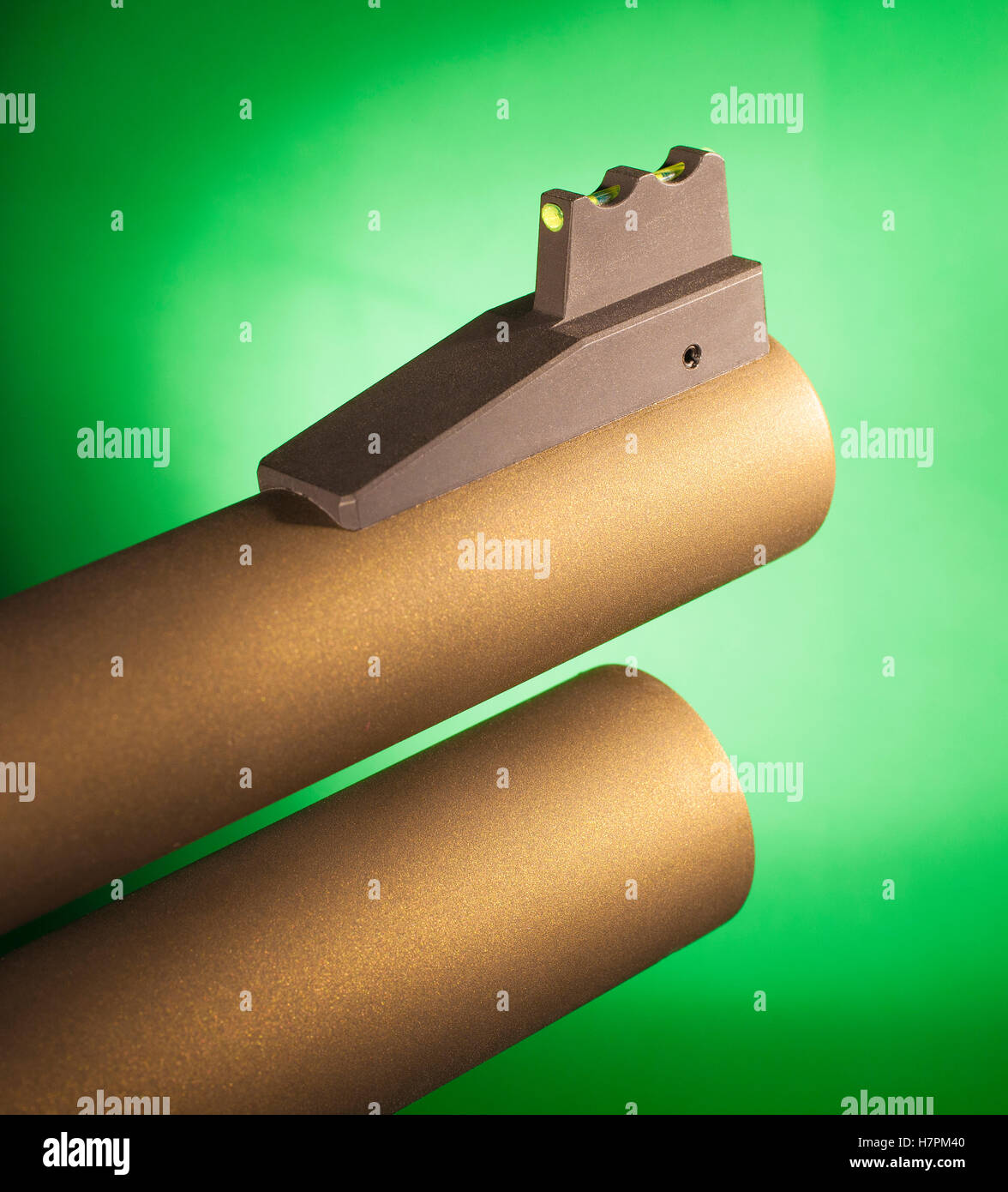 Fiber optic front sight on a gold colored shotgun with a green ...