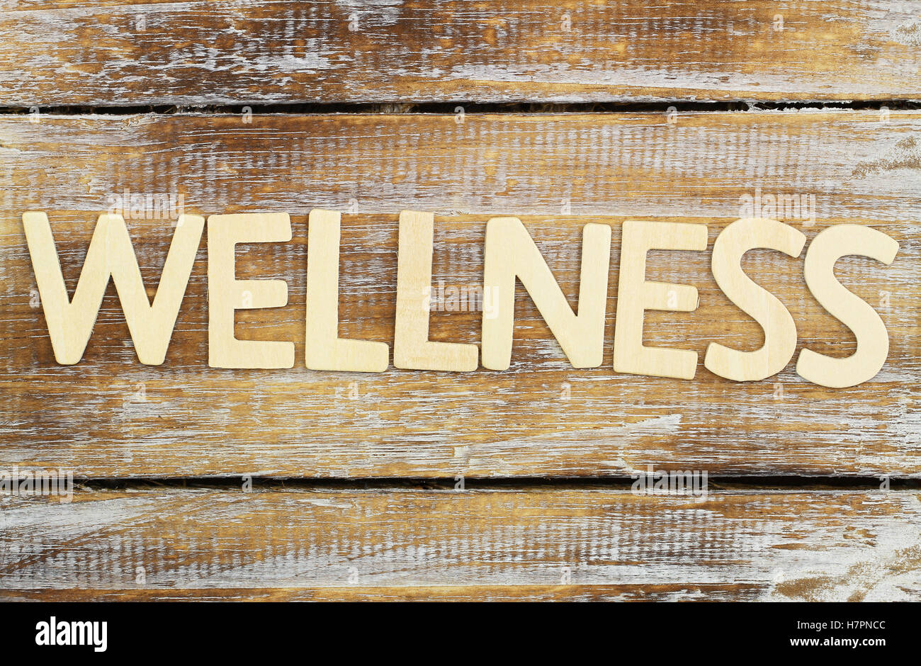 Word wellness written with wooden letters on rustic wooden surface ...