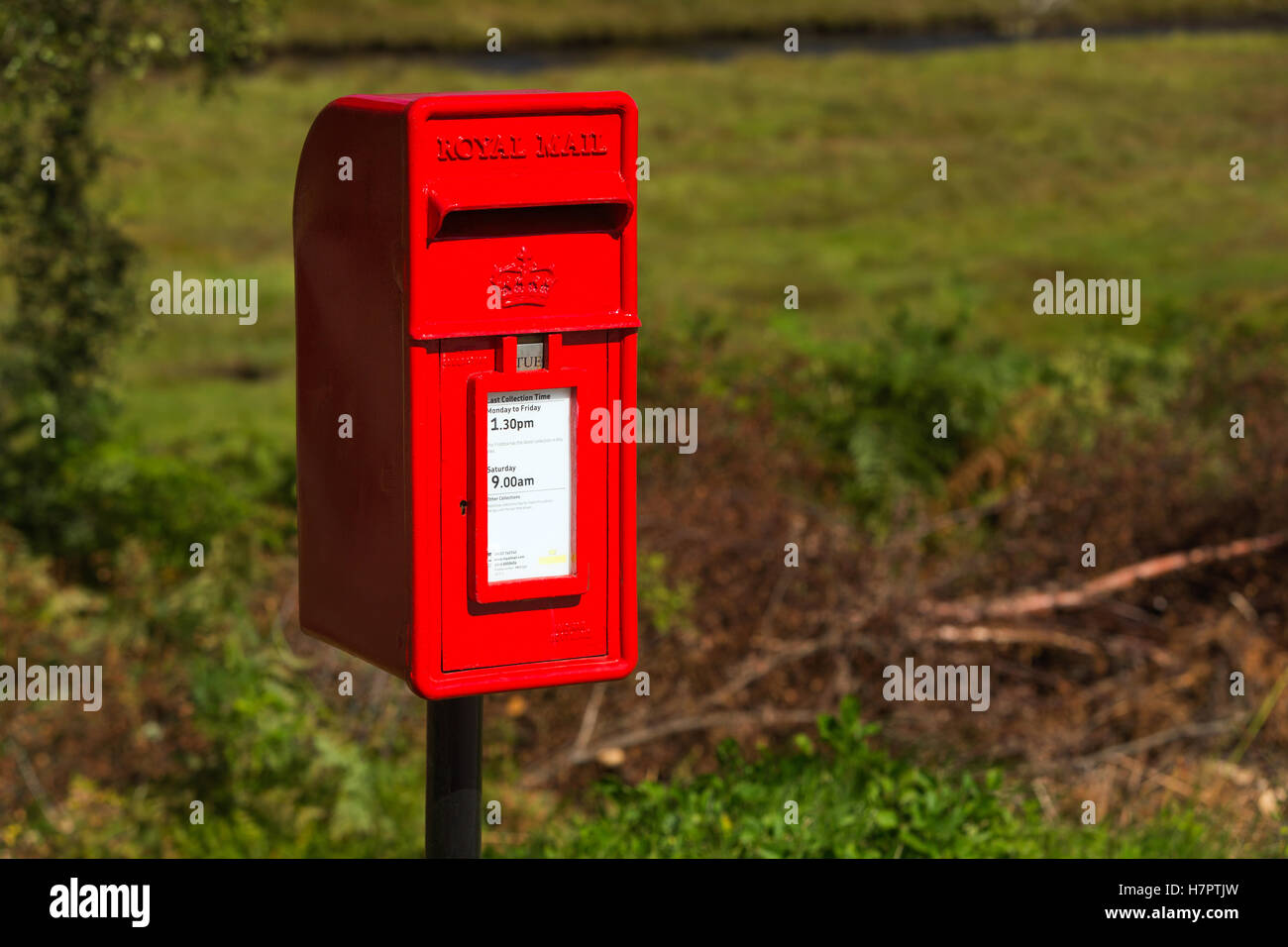 Red post letter box on countryside, rural environment, fields and ...