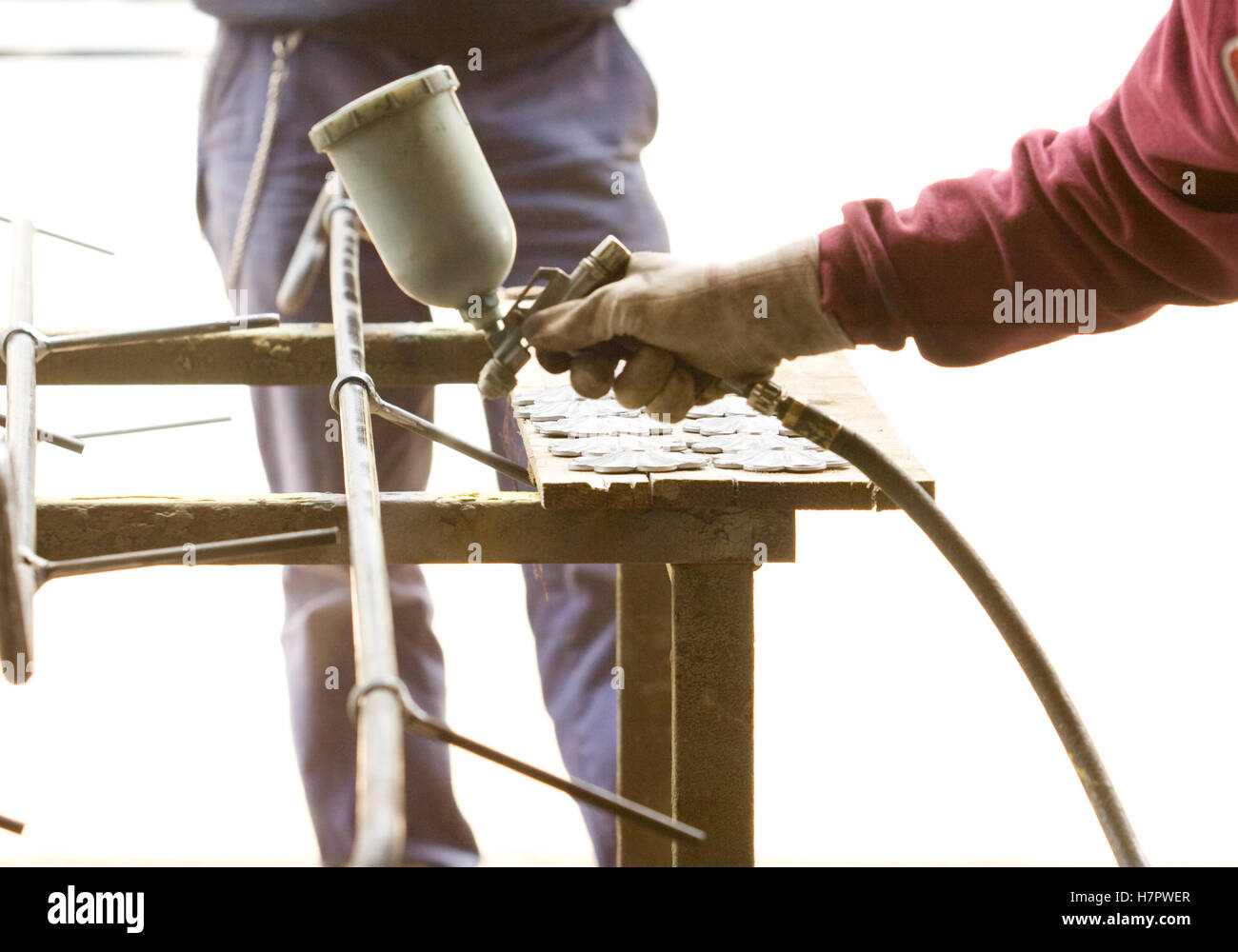craftsman painting an iron gate with a spray machine Stock Photo - Alamy