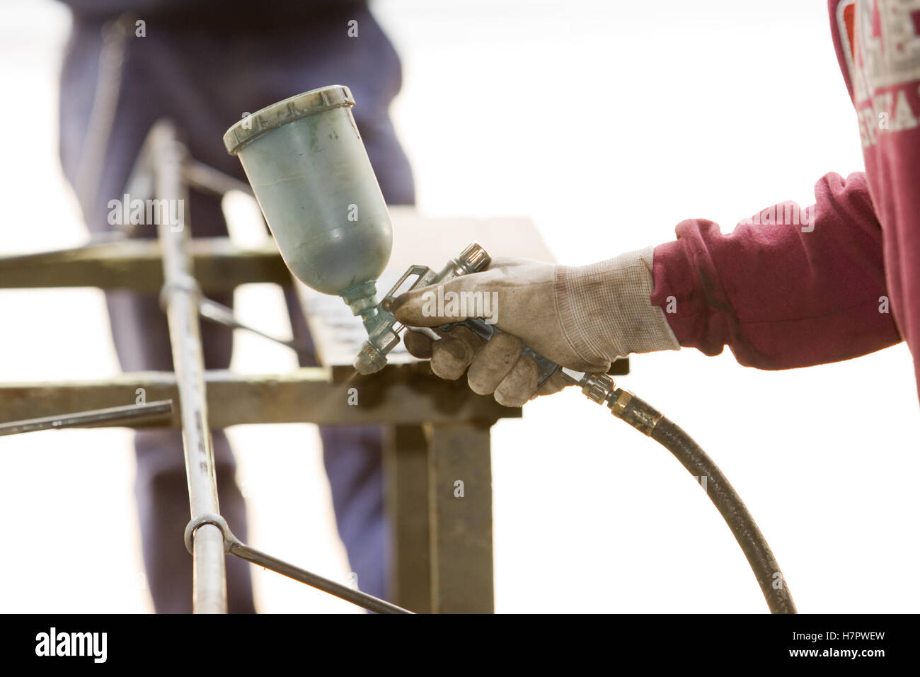 craftsman painting an iron gate with a spray machine Stock Photo - Alamy