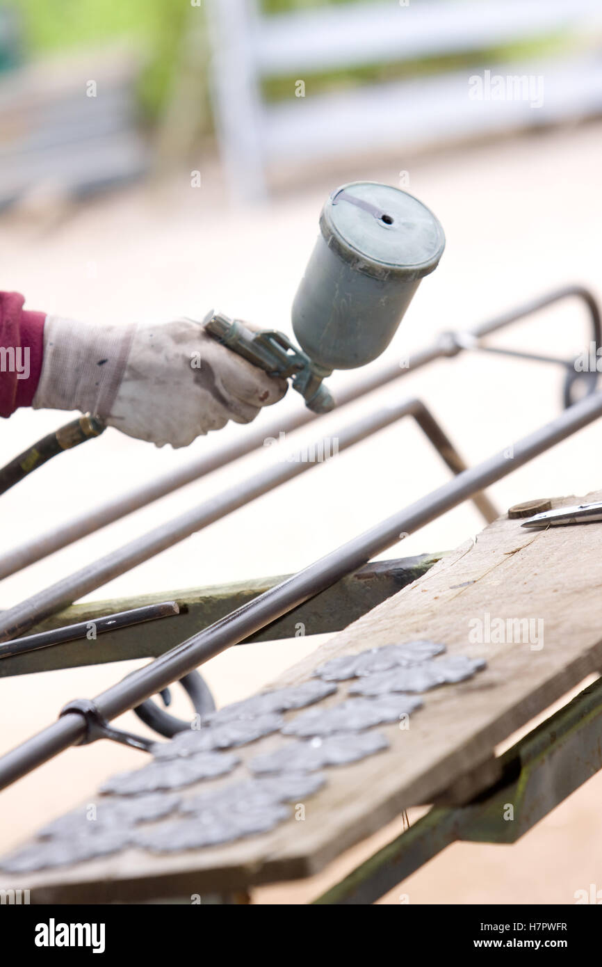 craftsman painting an iron gate with a spray machine Stock Photo - Alamy