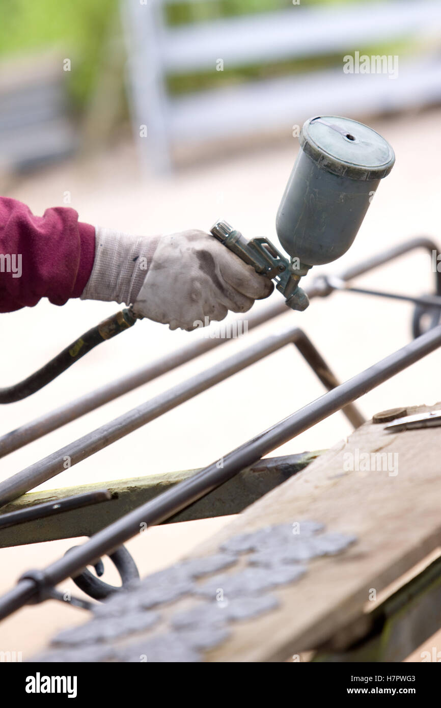 craftsman painting an iron gate with a spray machine Stock Photo - Alamy