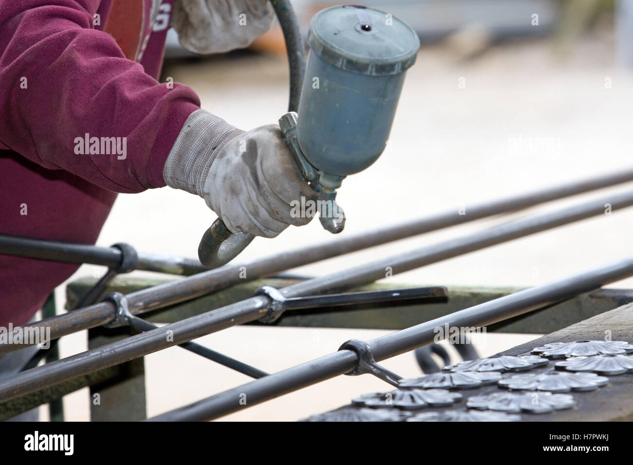 craftsman painting an iron gate with a spray machine Stock Photo - Alamy