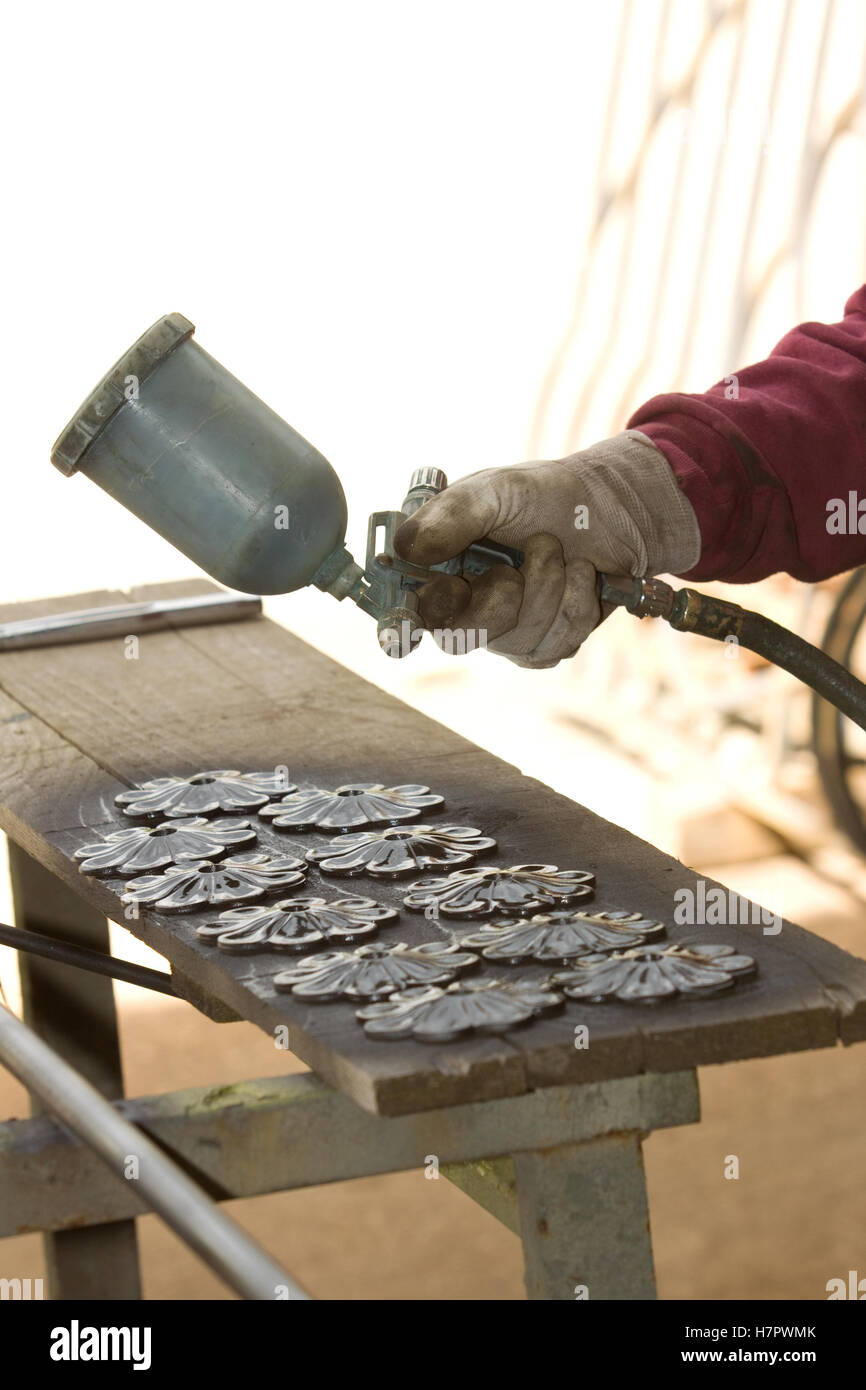 craftsman painting an iron gate with a spray machine Stock Photo - Alamy