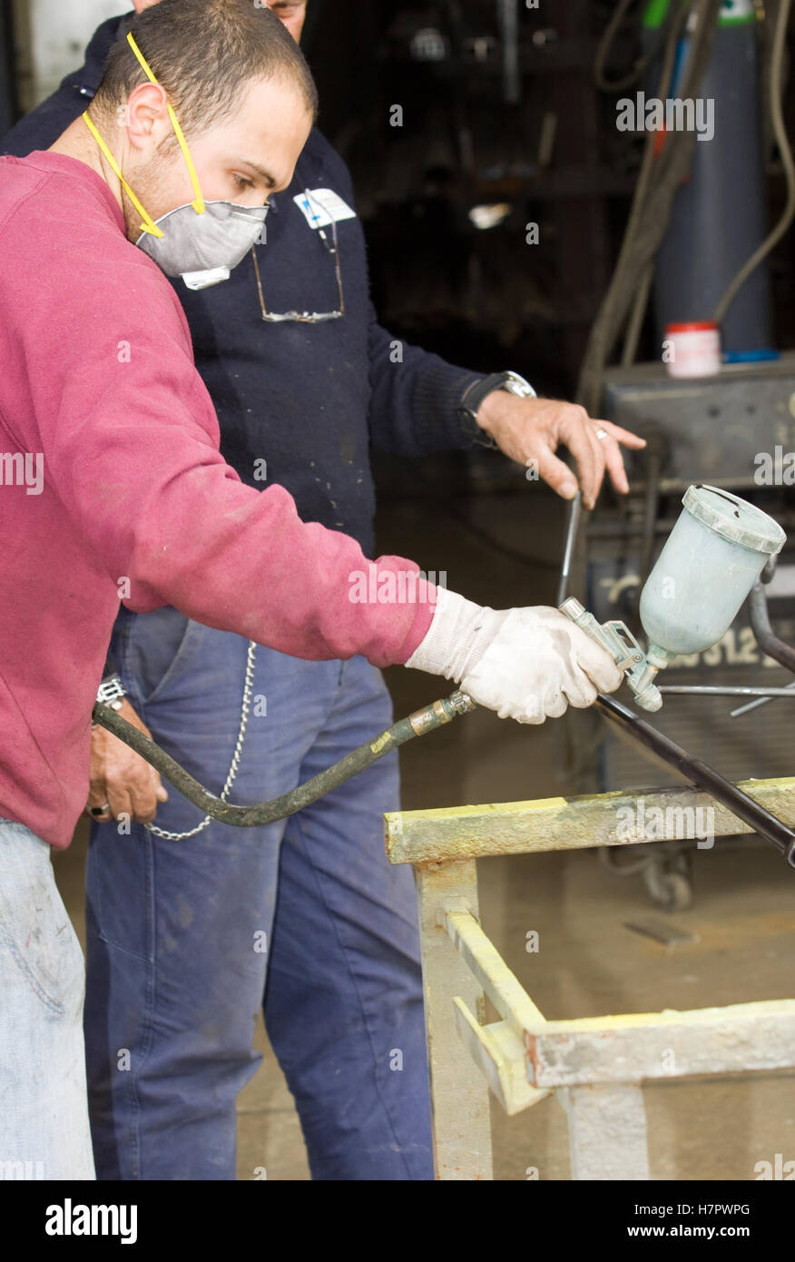craftsman painting an iron gate with a spray machine Stock Photo - Alamy