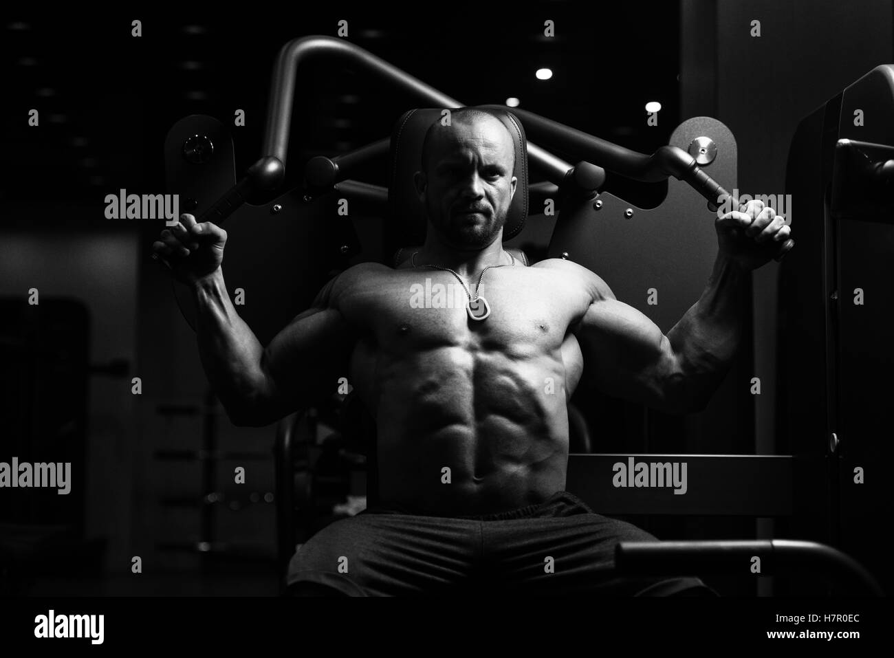 Big Man In The Gym And Exercising Back On Machine - Muscular Athletic ...