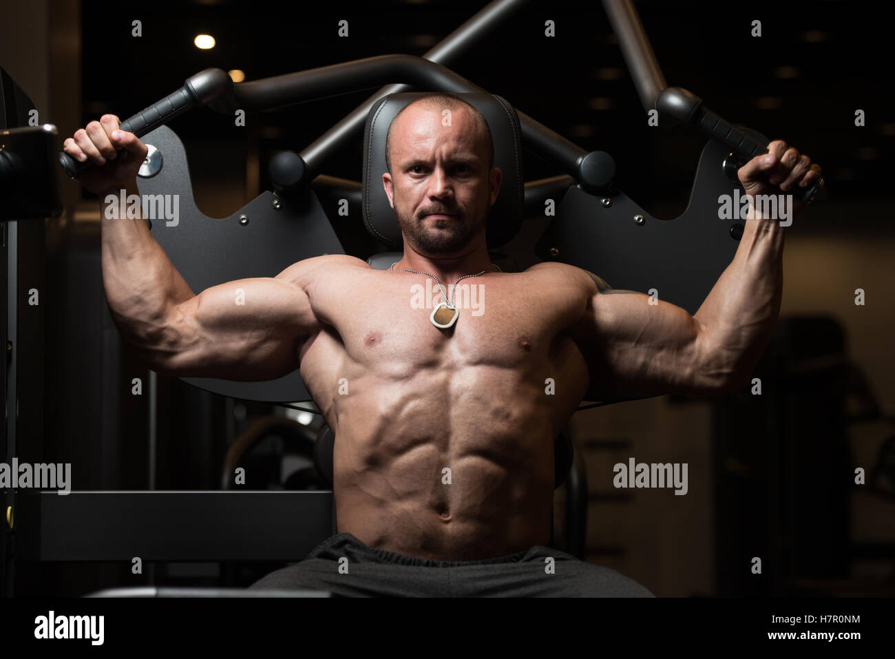 Big Man In The Gym And Exercising Back On Machine - Muscular Athletic ...