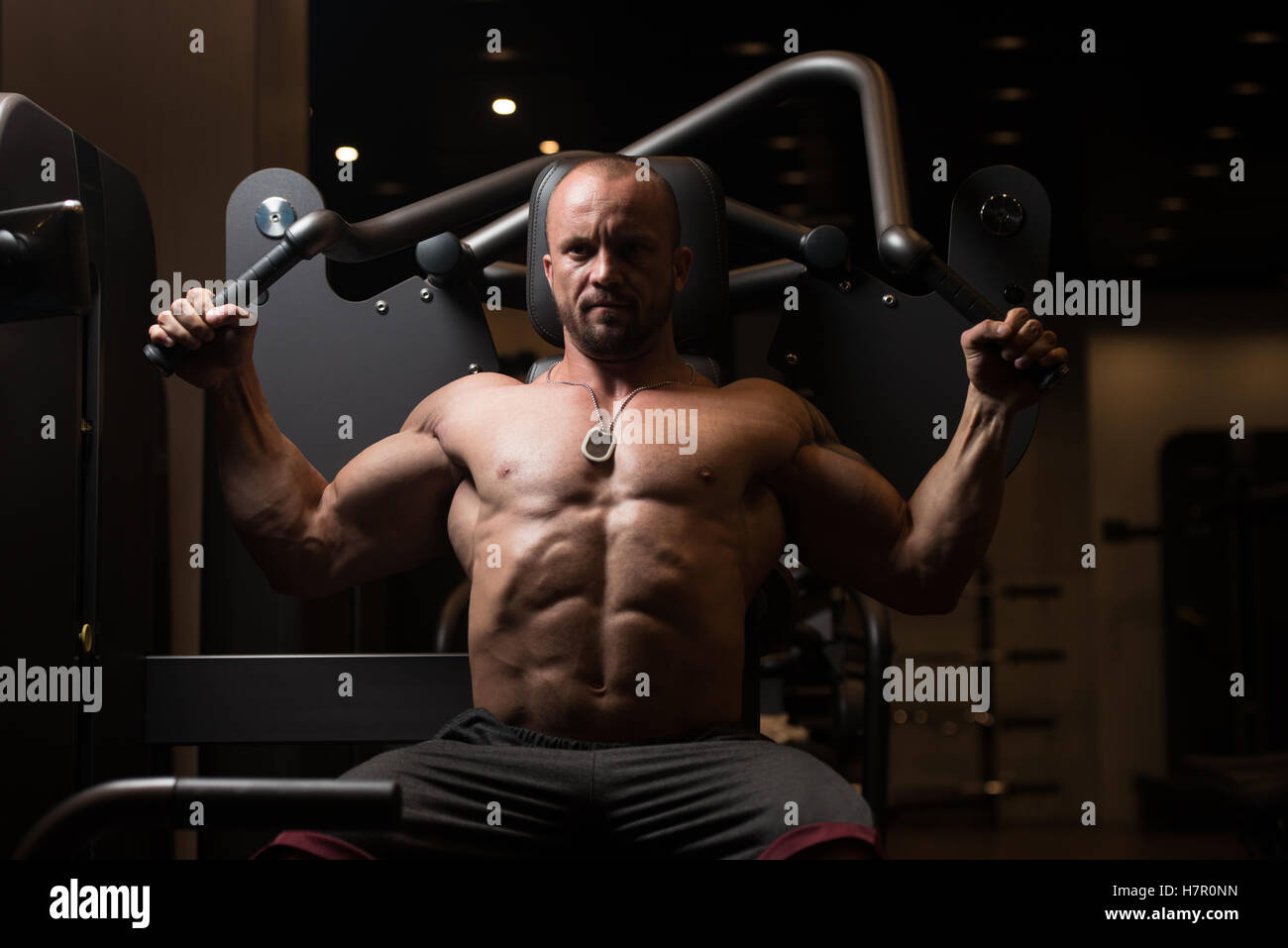 Big Man In The Gym And Exercising Back On Machine - Muscular Athletic ...