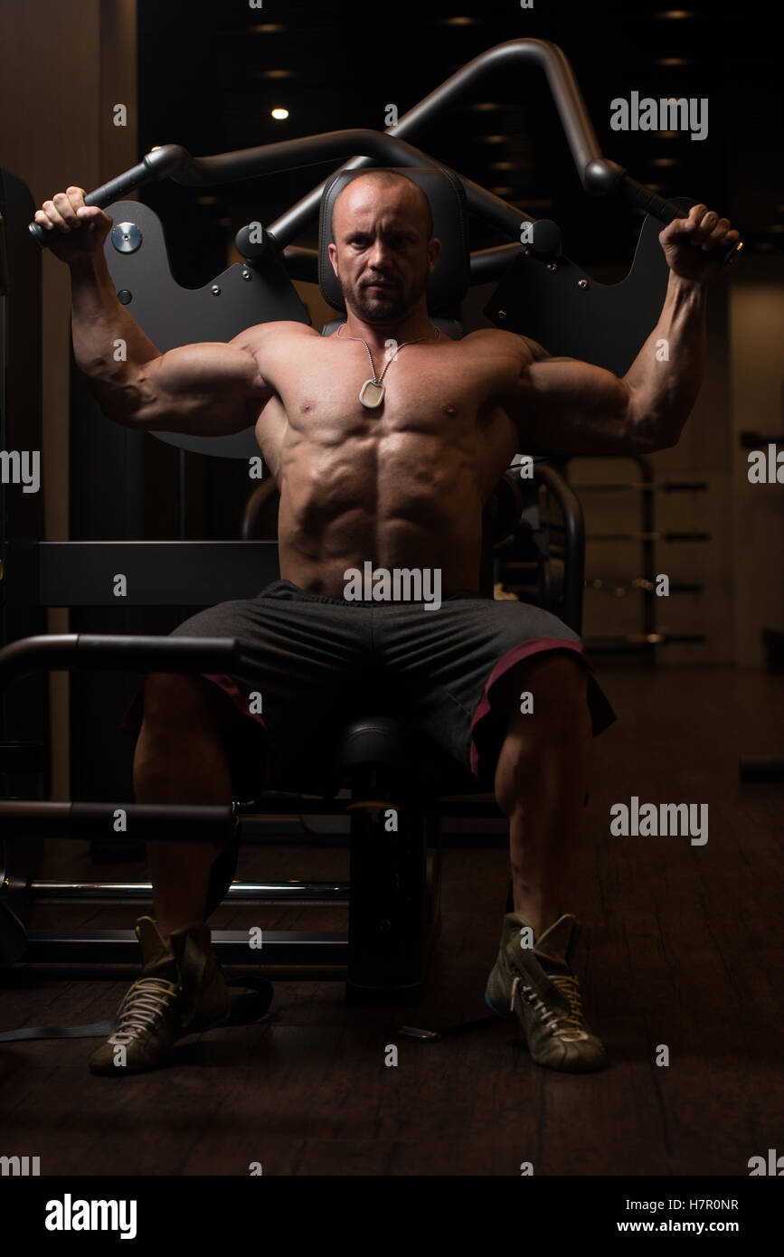 Big Man In The Gym And Exercising Back On Machine - Muscular Athletic ...