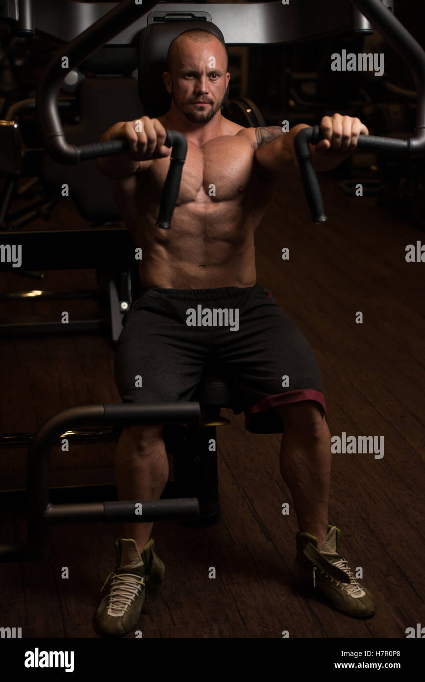 Big Man In The Gym Is Exercising Back On Machine - Muscular Athletic ...